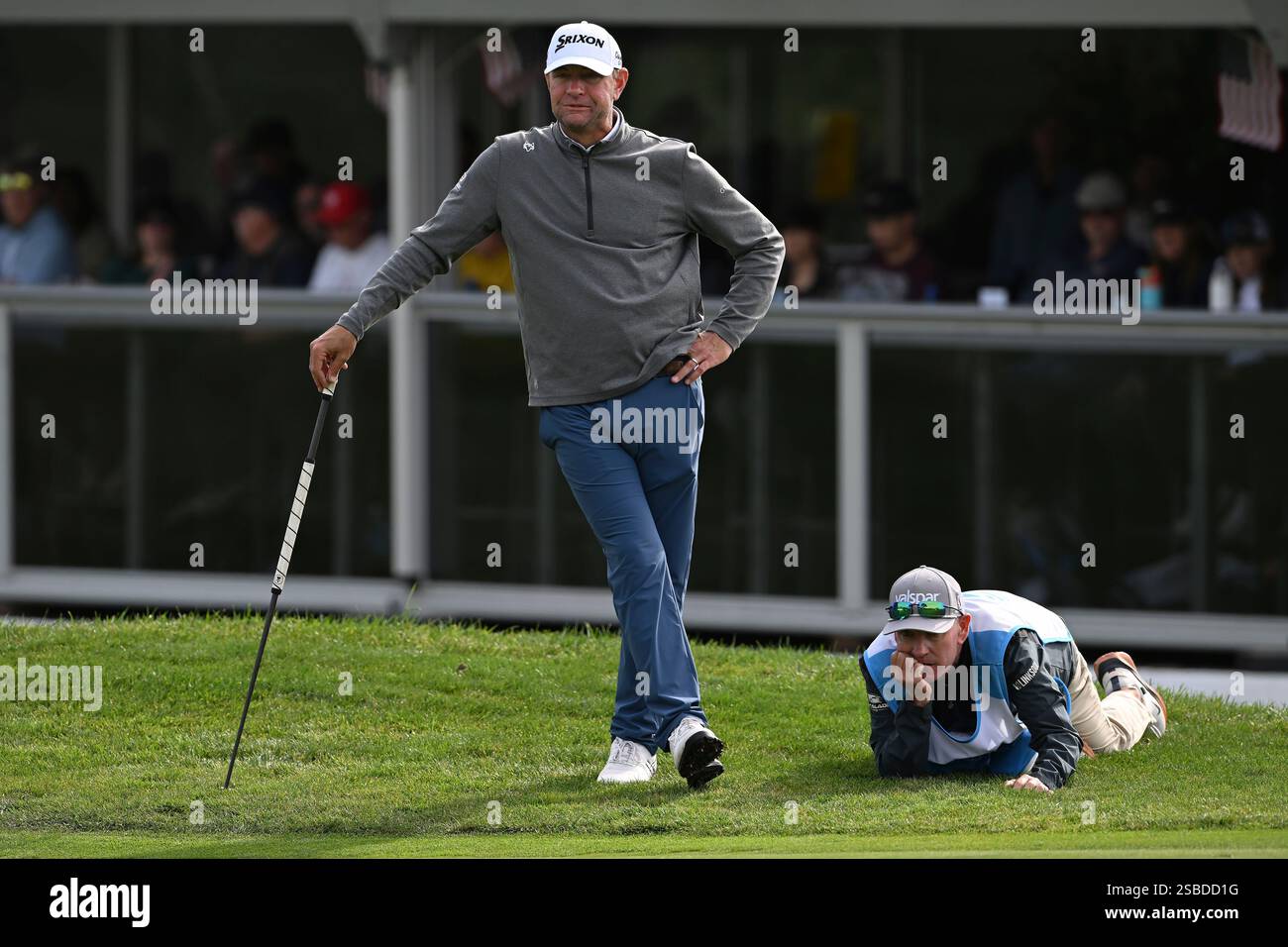 Lucas Glover, left, stands as his caddie lines a putt hits on the 15th ...