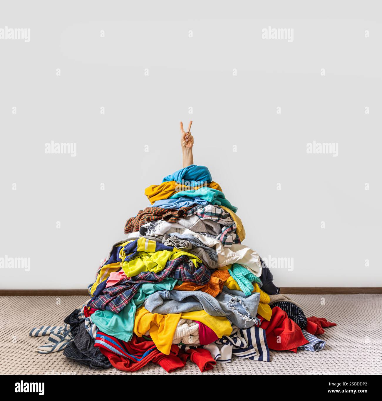 Unrecognizable human raises arm reaches out heap of colorful unfolded ...