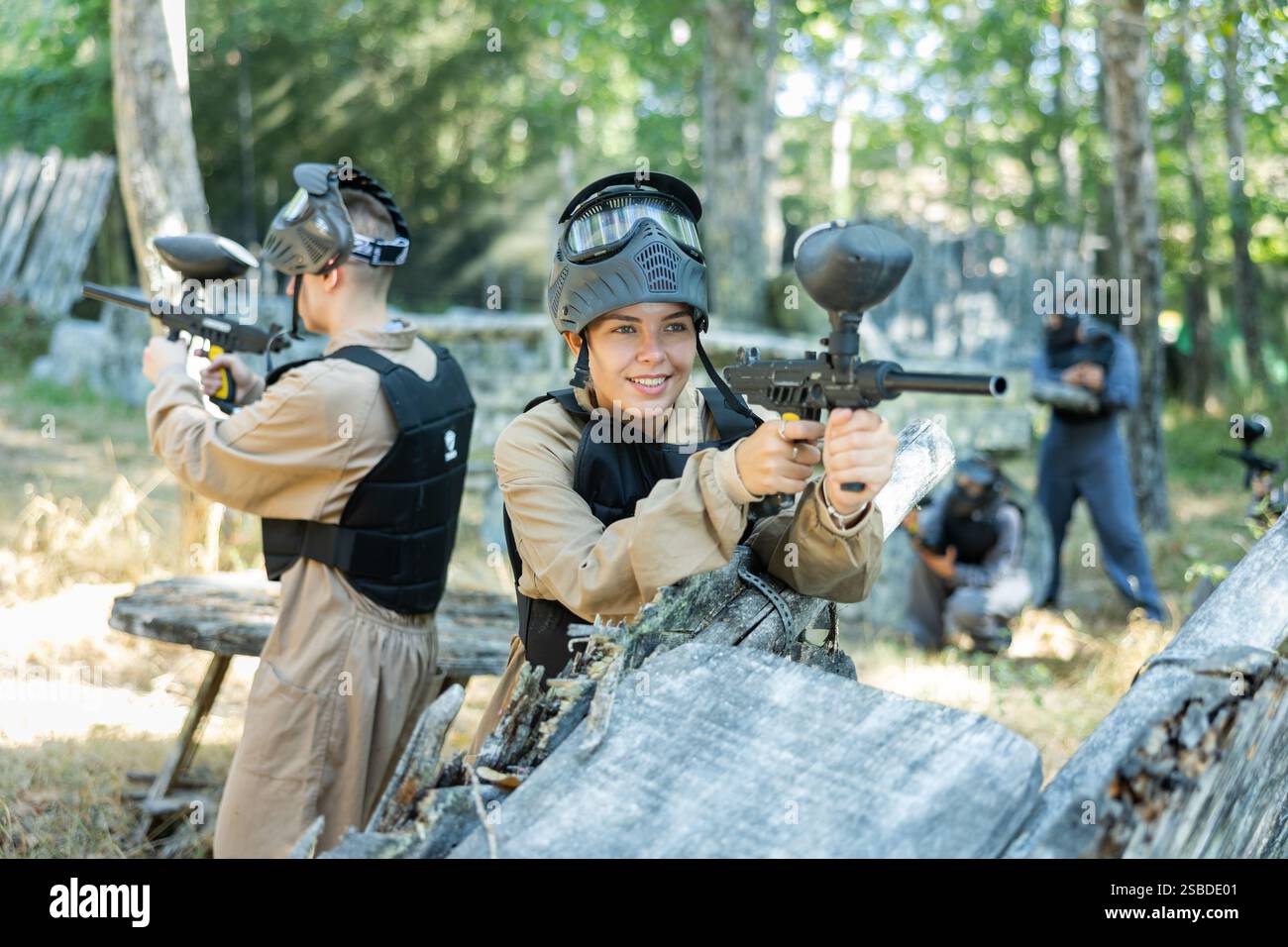 Happy girl targeting shooting with paintball marker Stock Photo - Alamy
