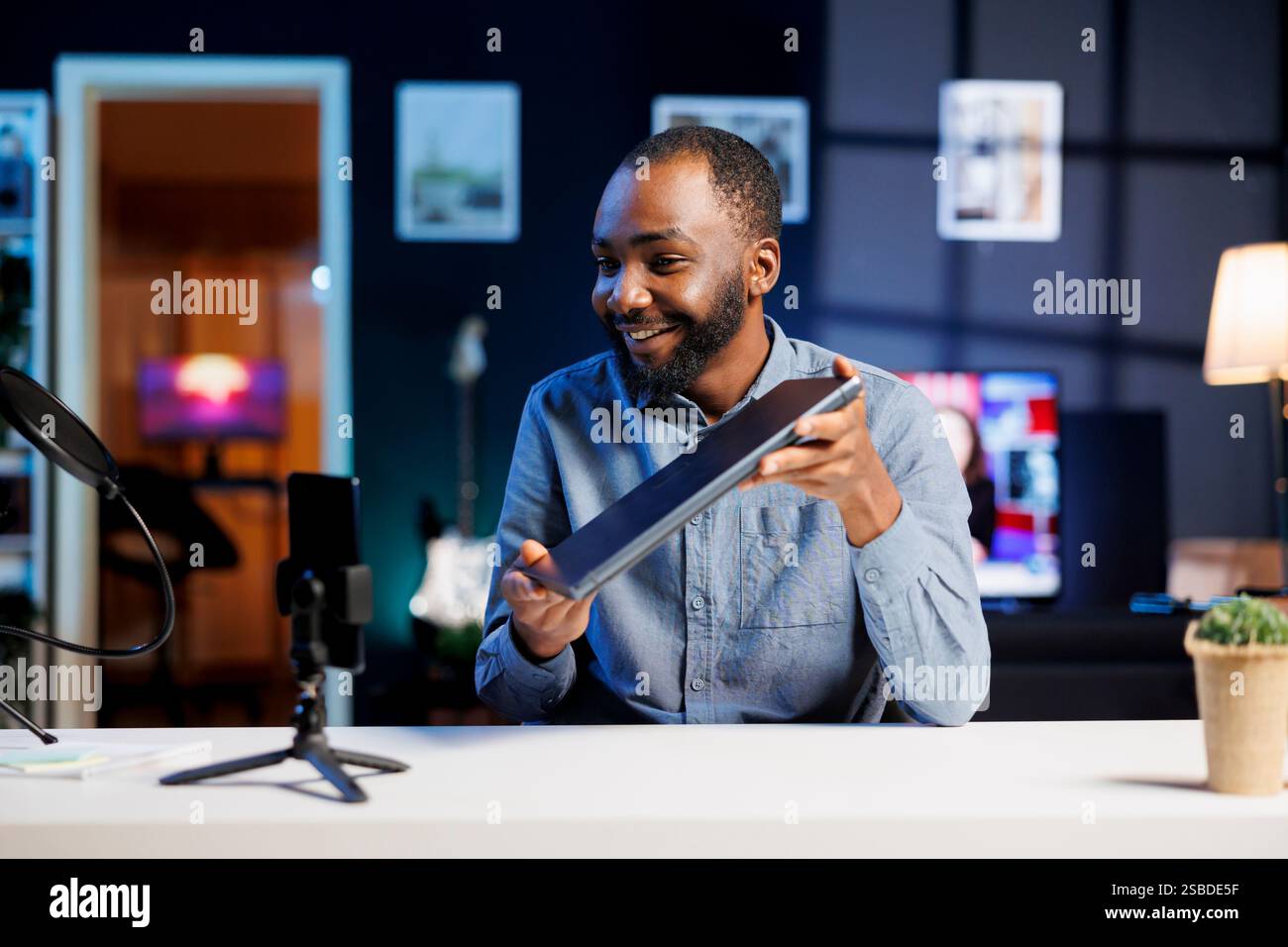 Smartphone on holder capturing footage of happy reviewer discussing ...