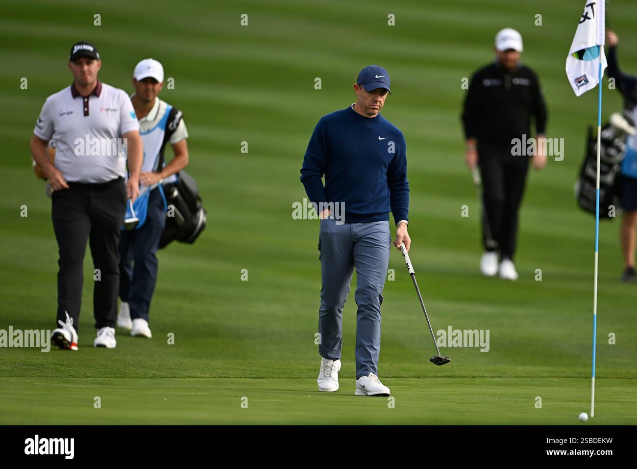 Rory McIlroy, of Northern Ireland, middle, walks toward the 15th green in front of Sepp Straka ...