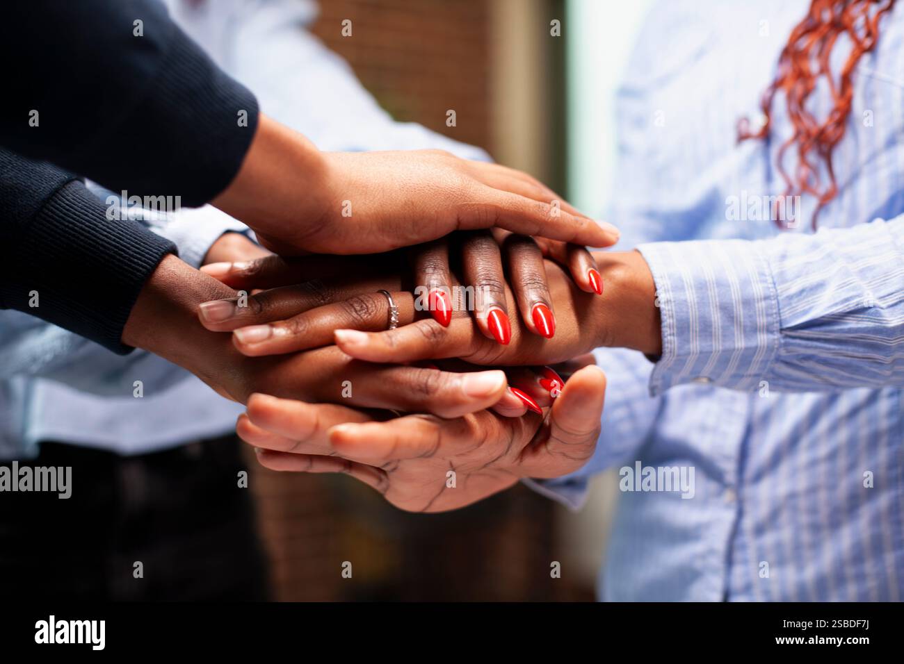 Closeup of hands of black people stacked together, representing ...