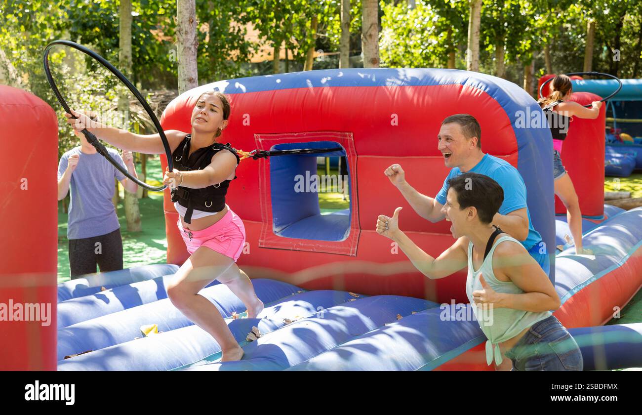 Girl reaching with hoop during competitive tug of war game Stock Photo ...