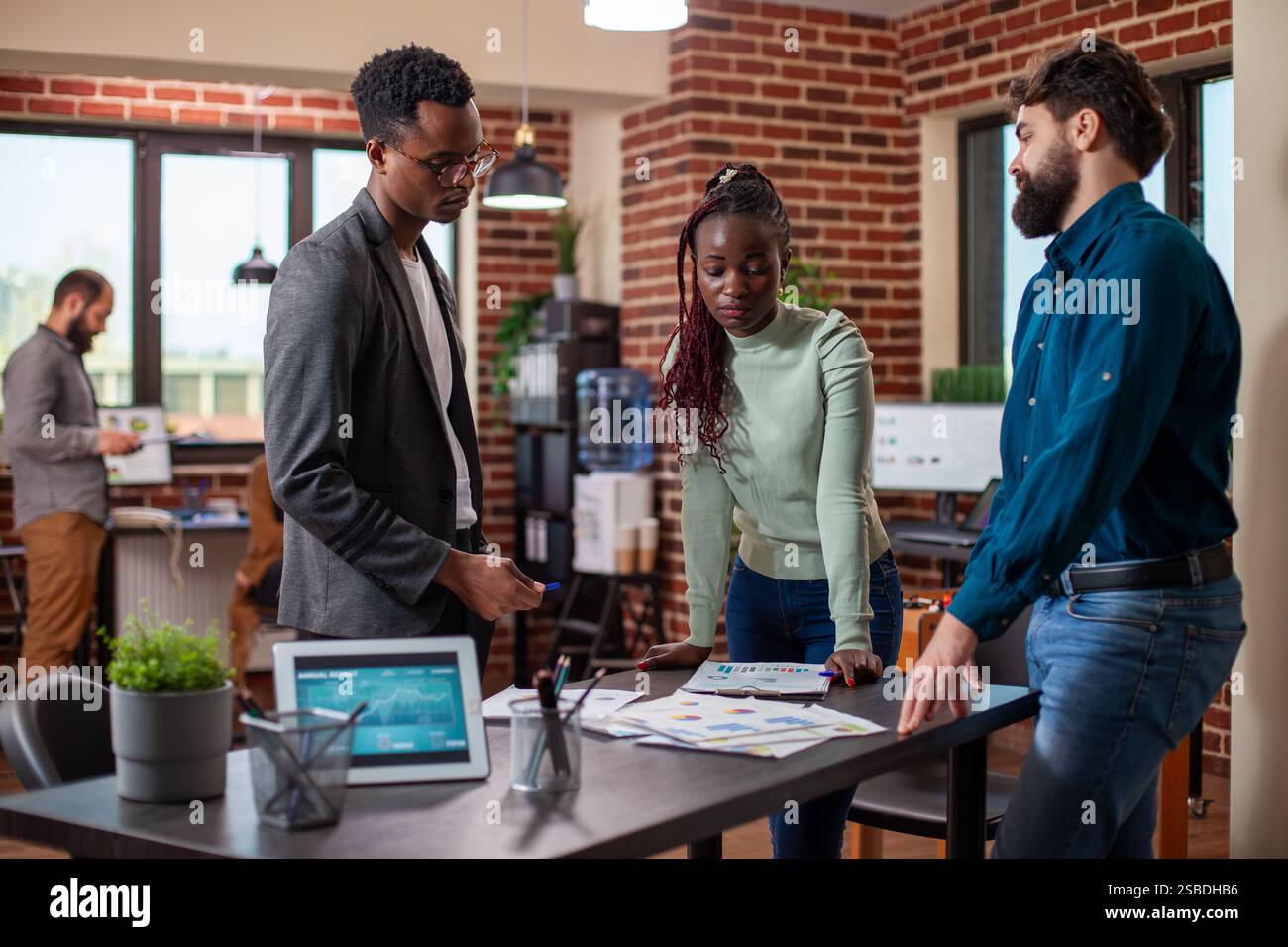 Businesswoman leads discussions in office, presenting project documents ...
