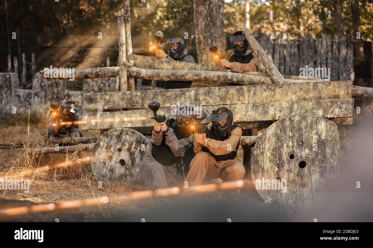 Group of people in full gear playing paintball on shooting range ...