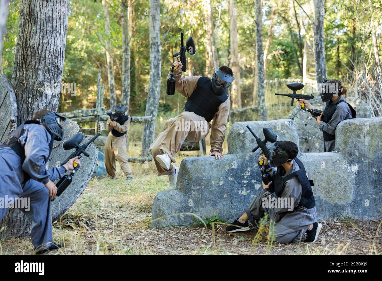 Team of paintball players attacks enemy at an army training ground ...