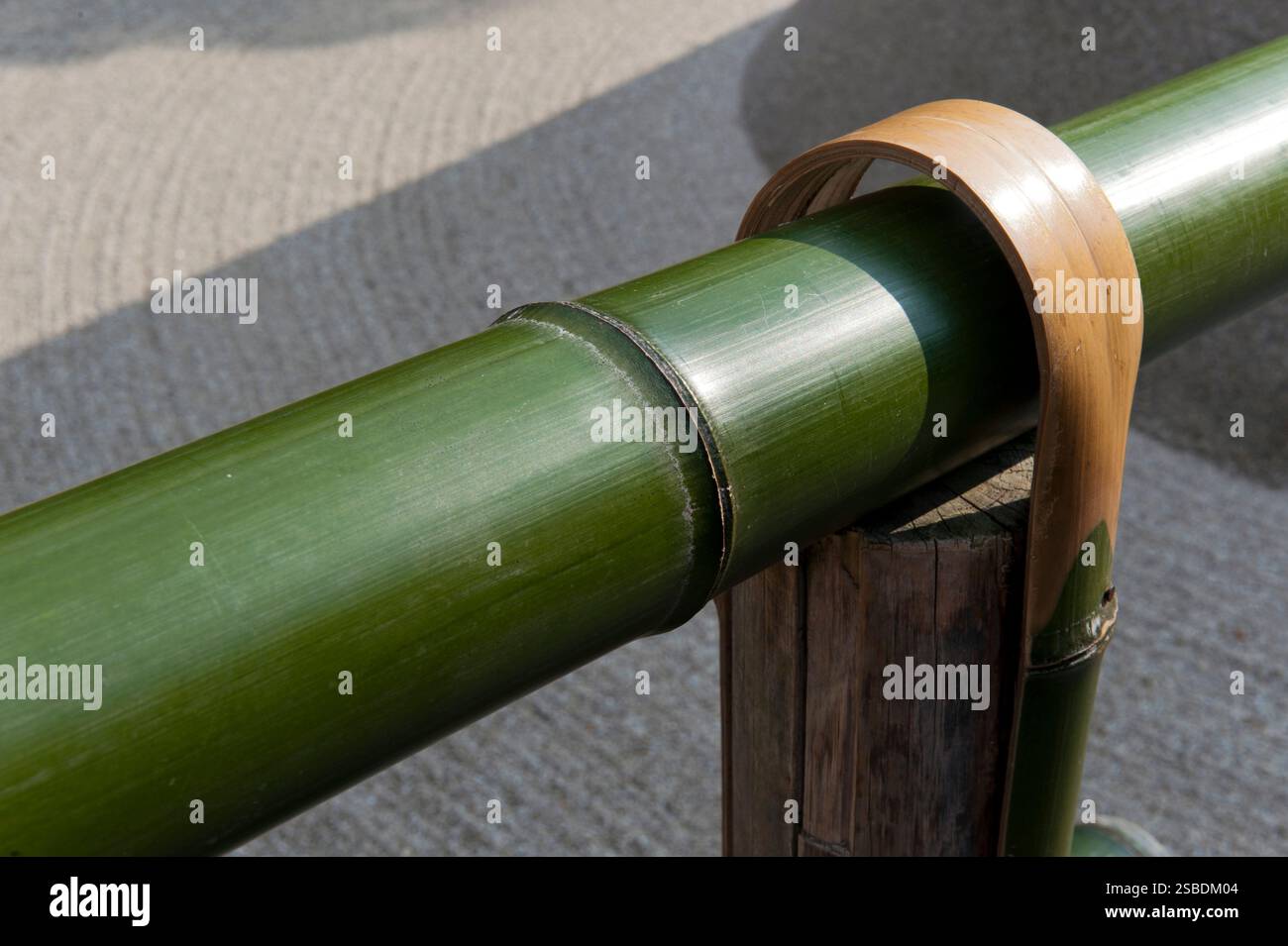 Bamboo railing with bamboo clamp beside a stone garden speaks to the ...