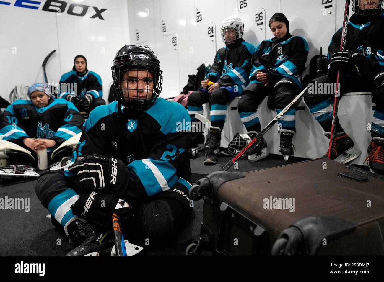 Members of Badpa women's ice hockey team listen to their coach before ...