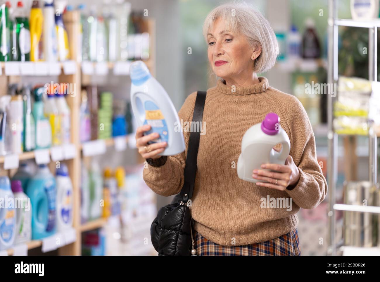 Mature woman choosing laundry detergent in department store Stock Photo ...