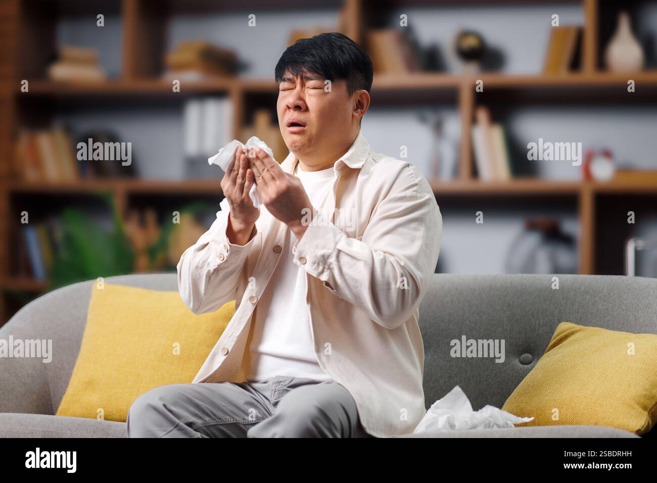 ill sick man, feeling unwell, having headache, asian man sitting on a ...