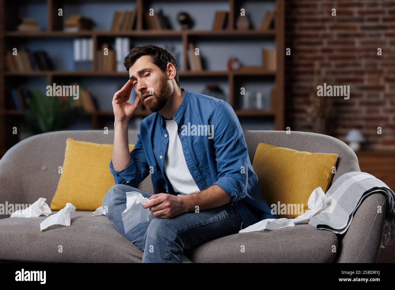 ill sick man, feeling unwell, having headache, Man sitting on a couch ...