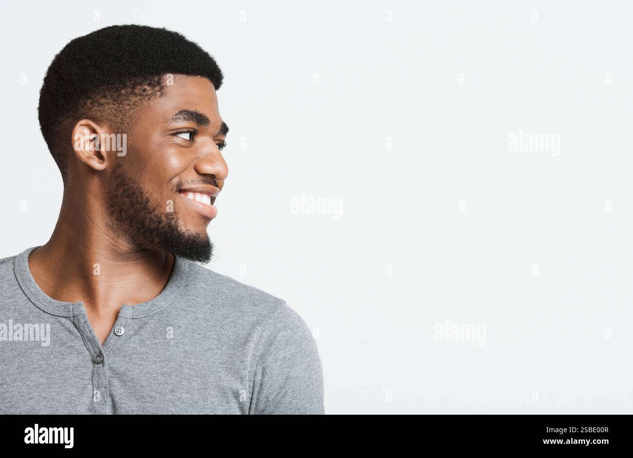 Half-turned smiling african-american man looking at copy space Stock ...