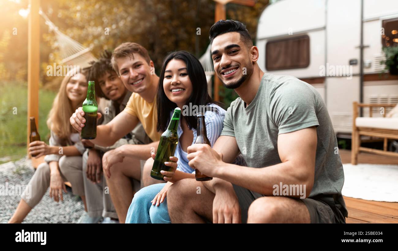 Diverse young friends having party near RV outdoors, drinking beer ...