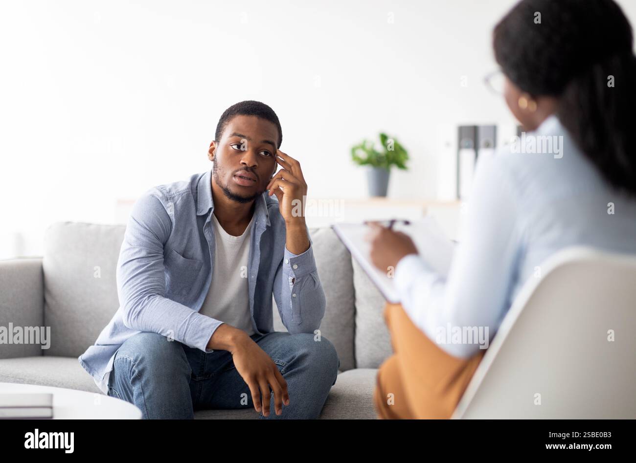 Stressed black man suffering from depression, counselor providing ...