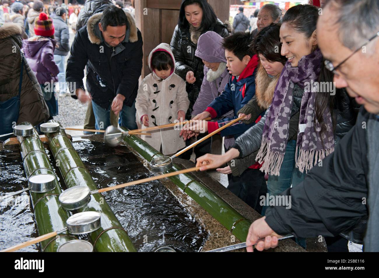People washing hands and mouth at a "temizuya" water basin in a ...