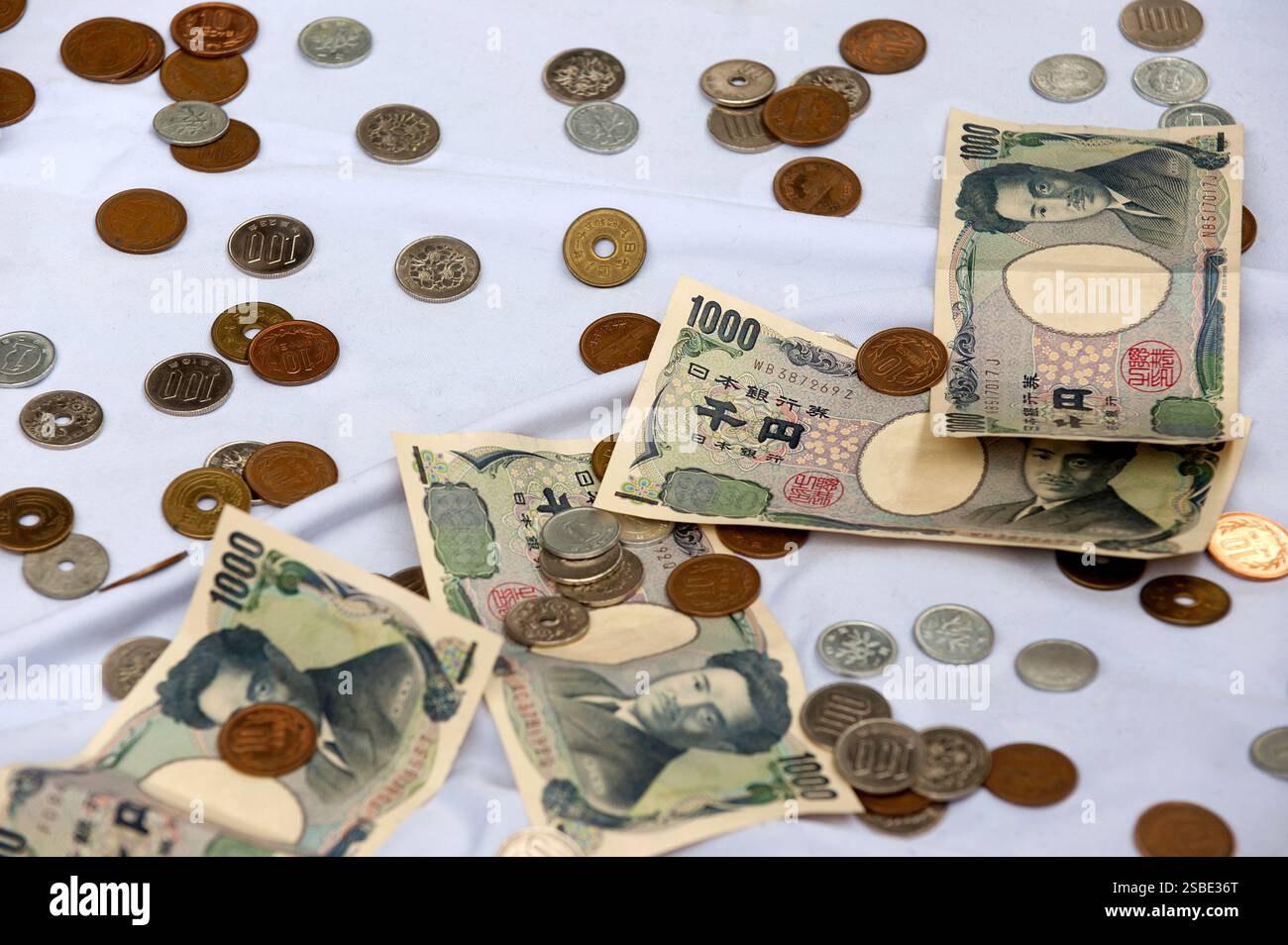 Japanese coins and banknotes tossed into an offertory box at a shrine ...
