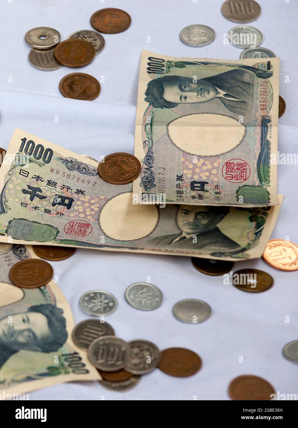 Japanese coins and banknotes tossed into an offertory box at a shrine ...