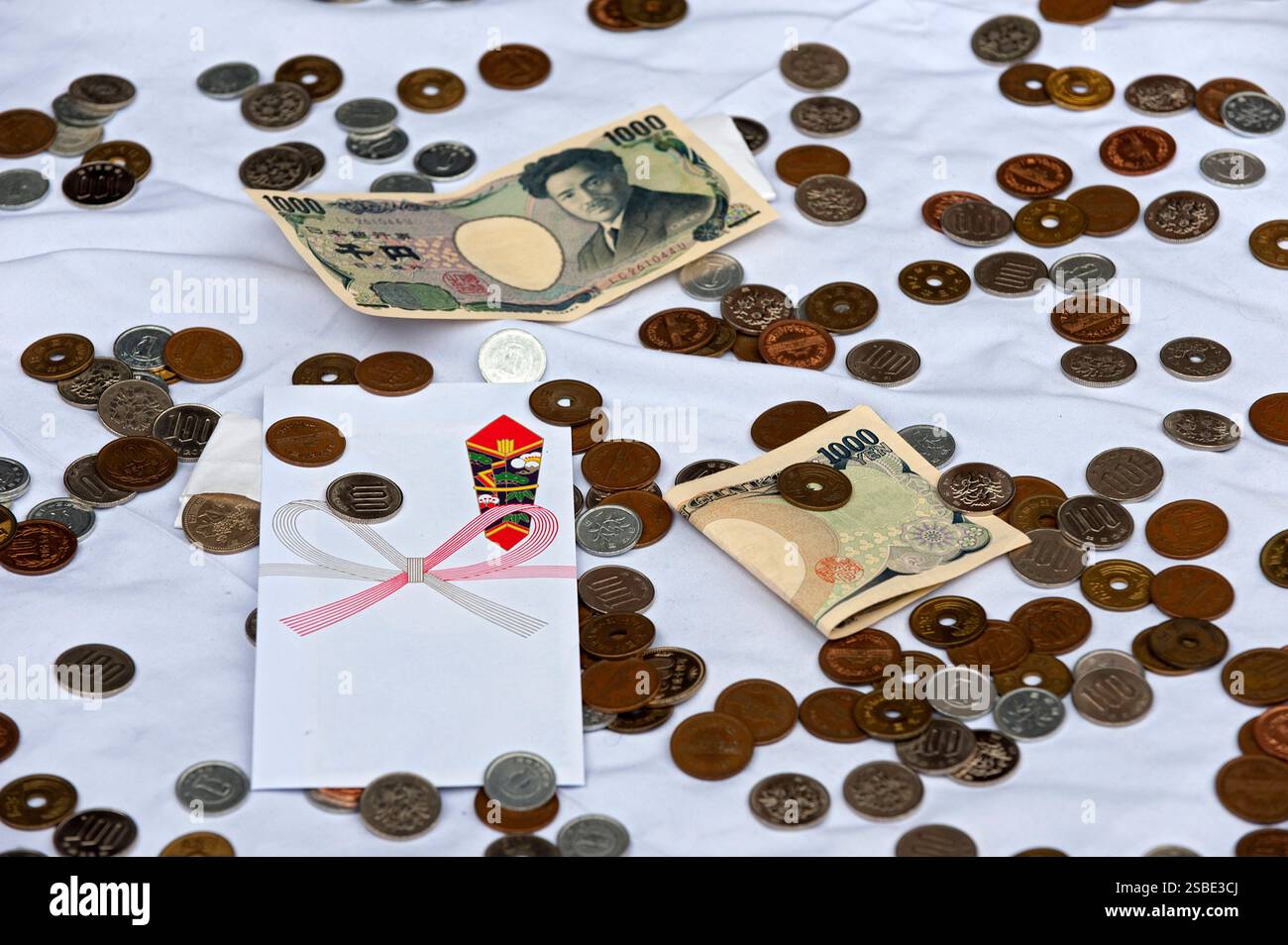 Japanese coins and banknotes tossed into an offertory box at a shrine ...