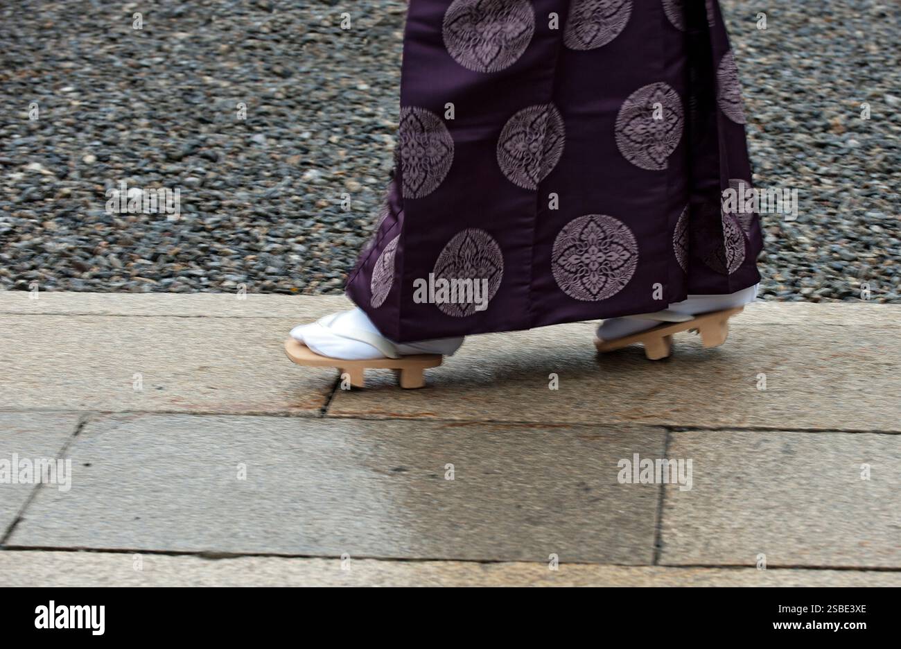A Japanese Shinto priest in kimono wearing traditional wooden geta ...