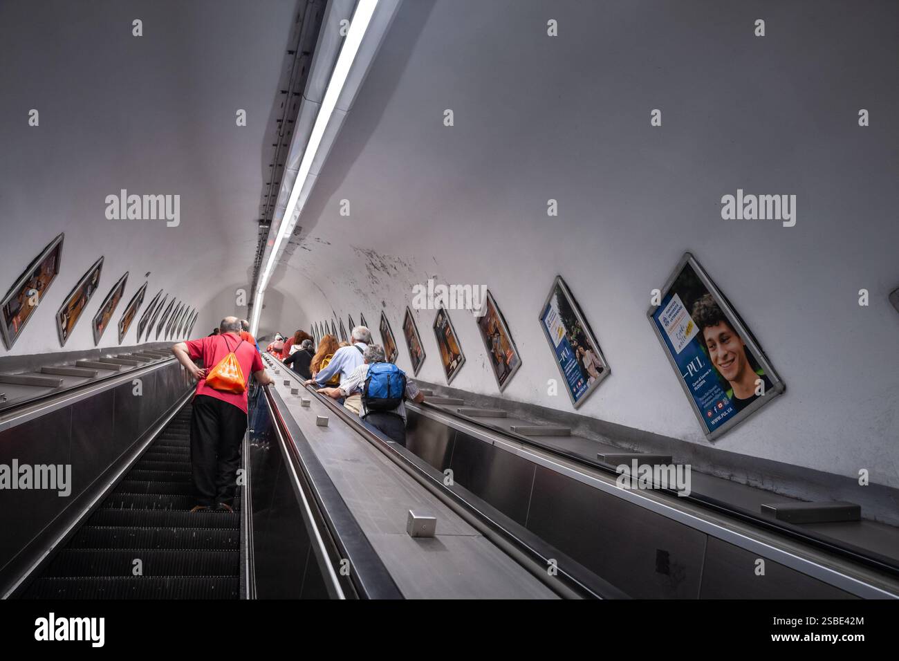 ROME, ITALY - JUNE 13, 2024: Commuters crowd an escalator in the city’s ...