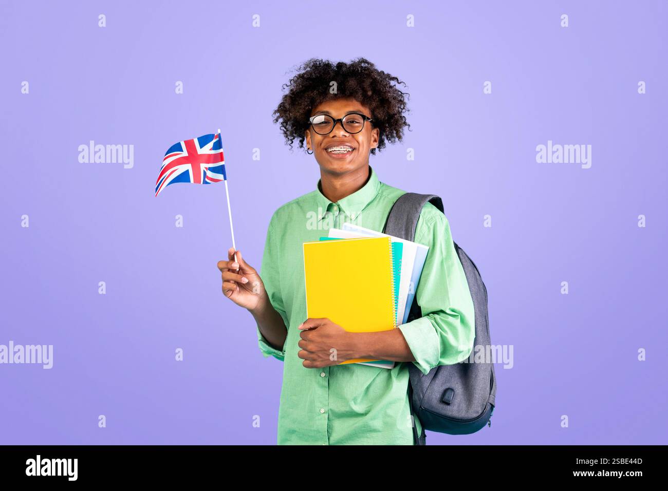 Happy african american teen exchange student with notebooks holding UK ...