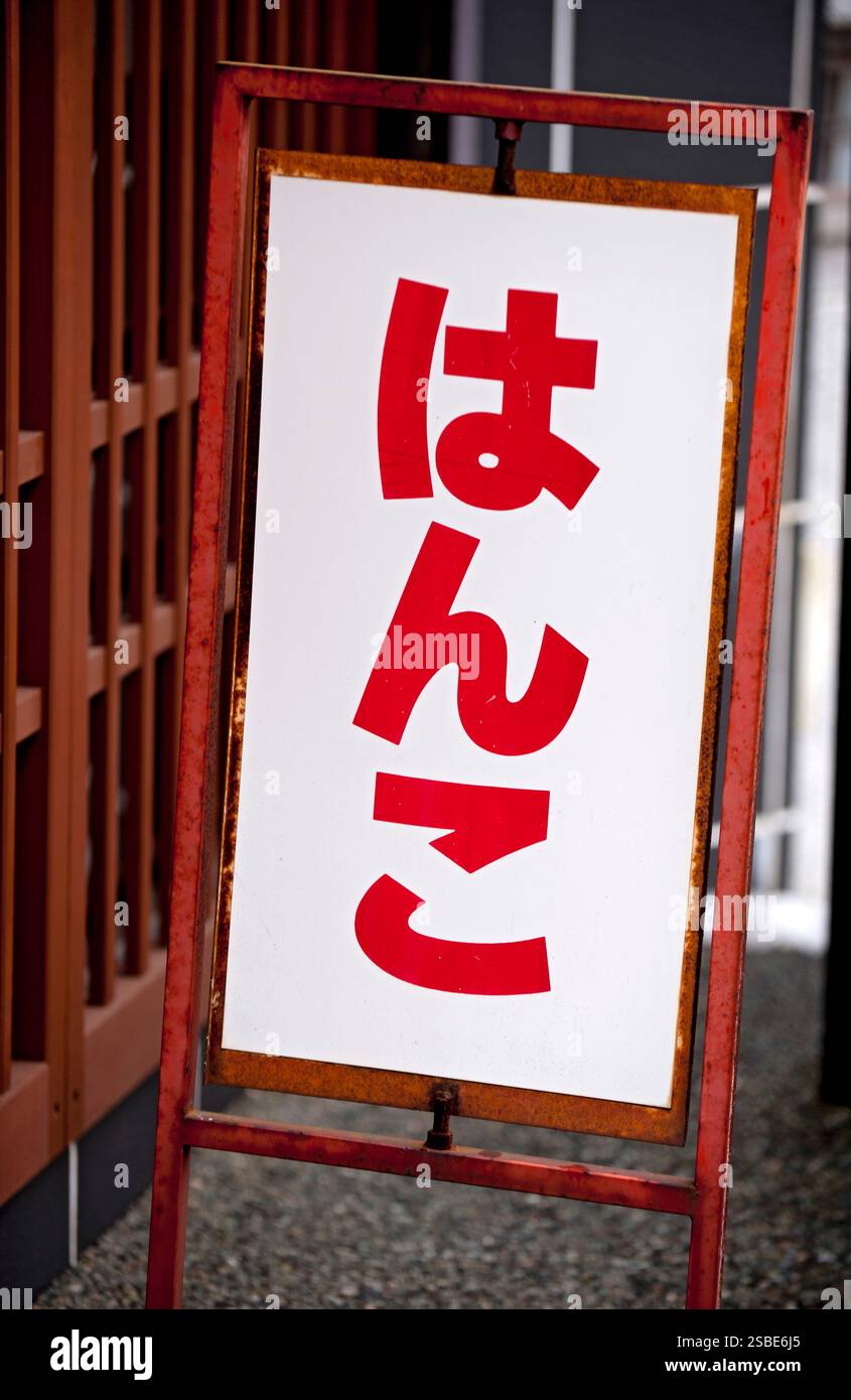Shop sign in red Japanese hiragana script says "hanko" (traditional ...