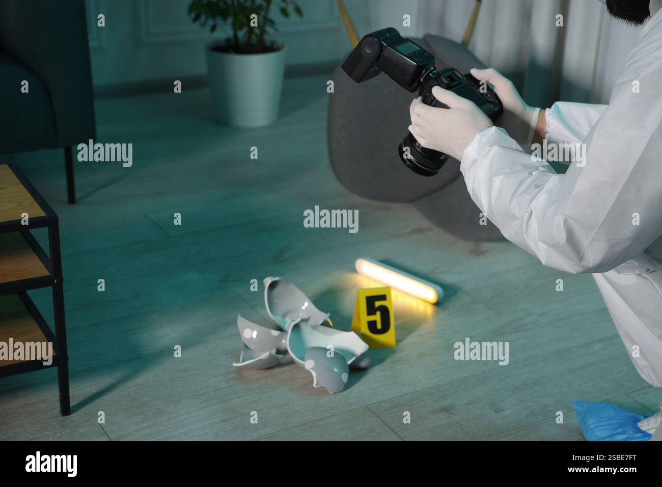 Forensic expert with camera taking photo of evidence at crime scene ...