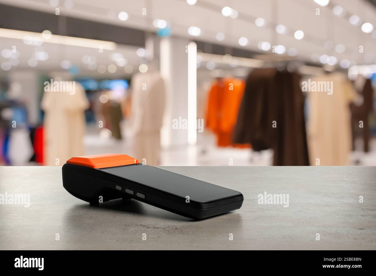 Payment terminal on grey counter in store Stock Photo - Alamy