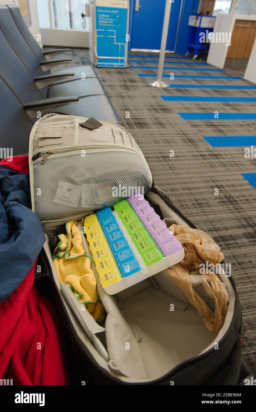 Wide view over opened carryon bag with muli colored pill pack inside ...