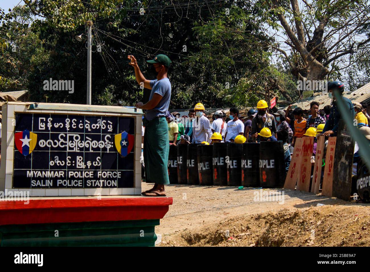 Villagers gathered and hold shields in front of the Salin police ...