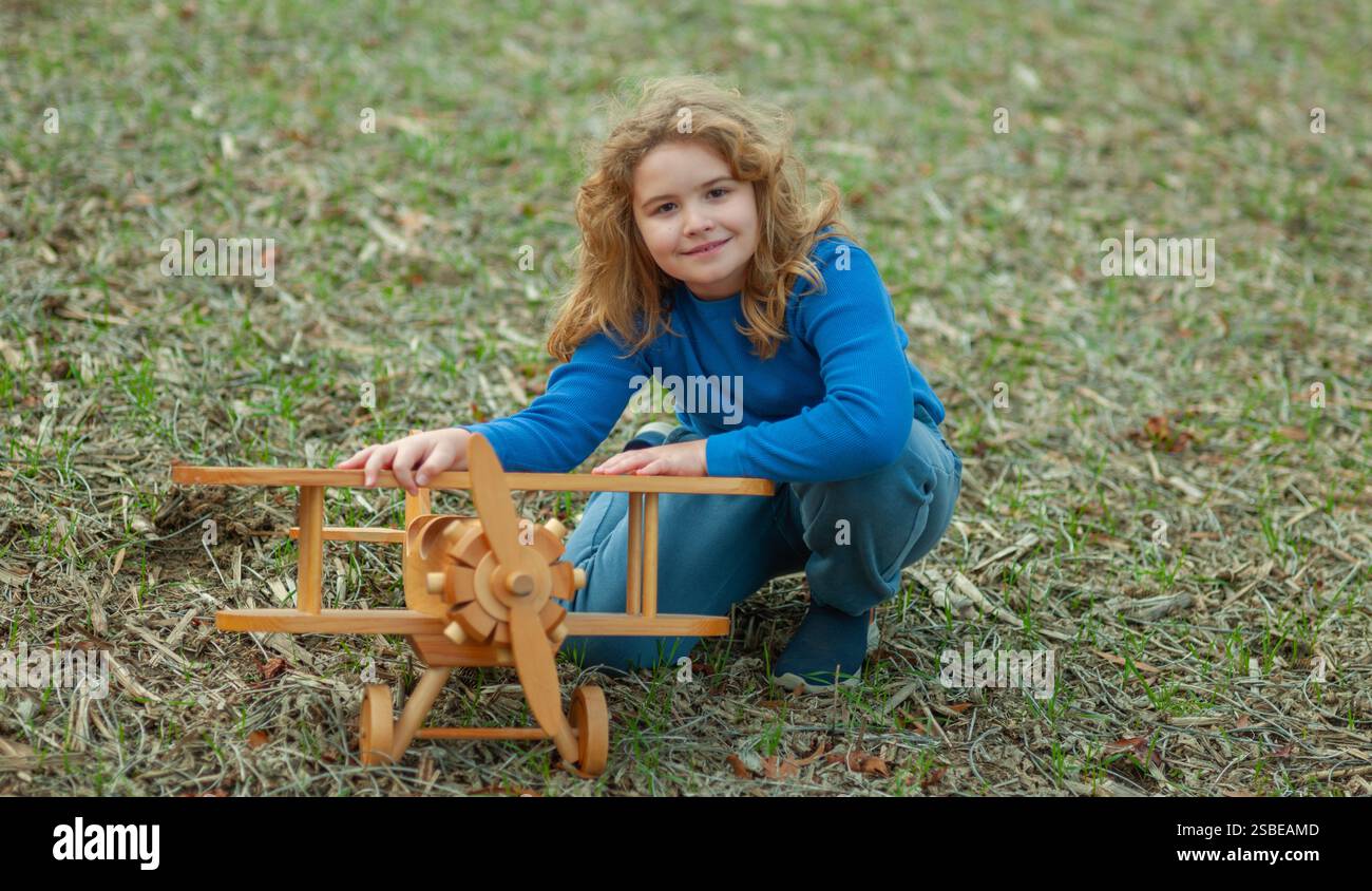 Kids dream. Happy kid play with wooden plane outdoor. Child playing ...