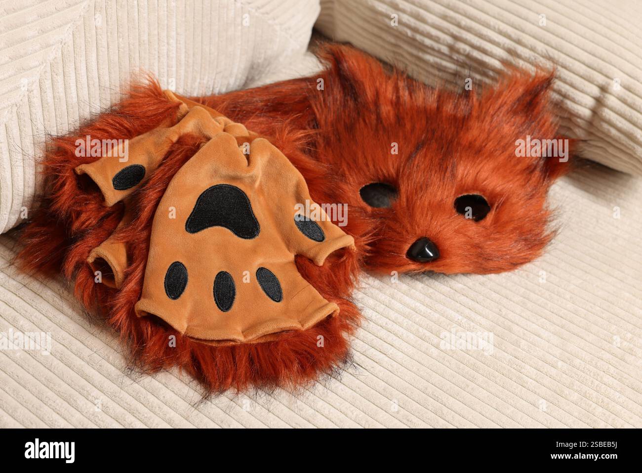 Quadrobics. Fox mask, gloves and tail on sofa indoors Stock Photo - Alamy