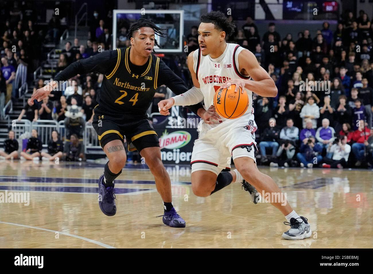 Wisconsin guard John Tonje, right, drives as Northwestern guard K.J ...