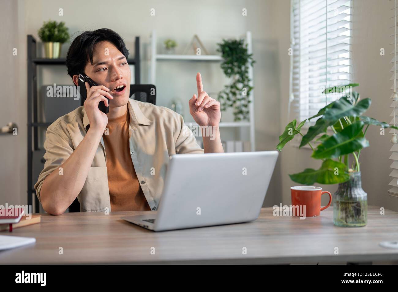 A professional Asian businessman is handling business over the phone in ...
