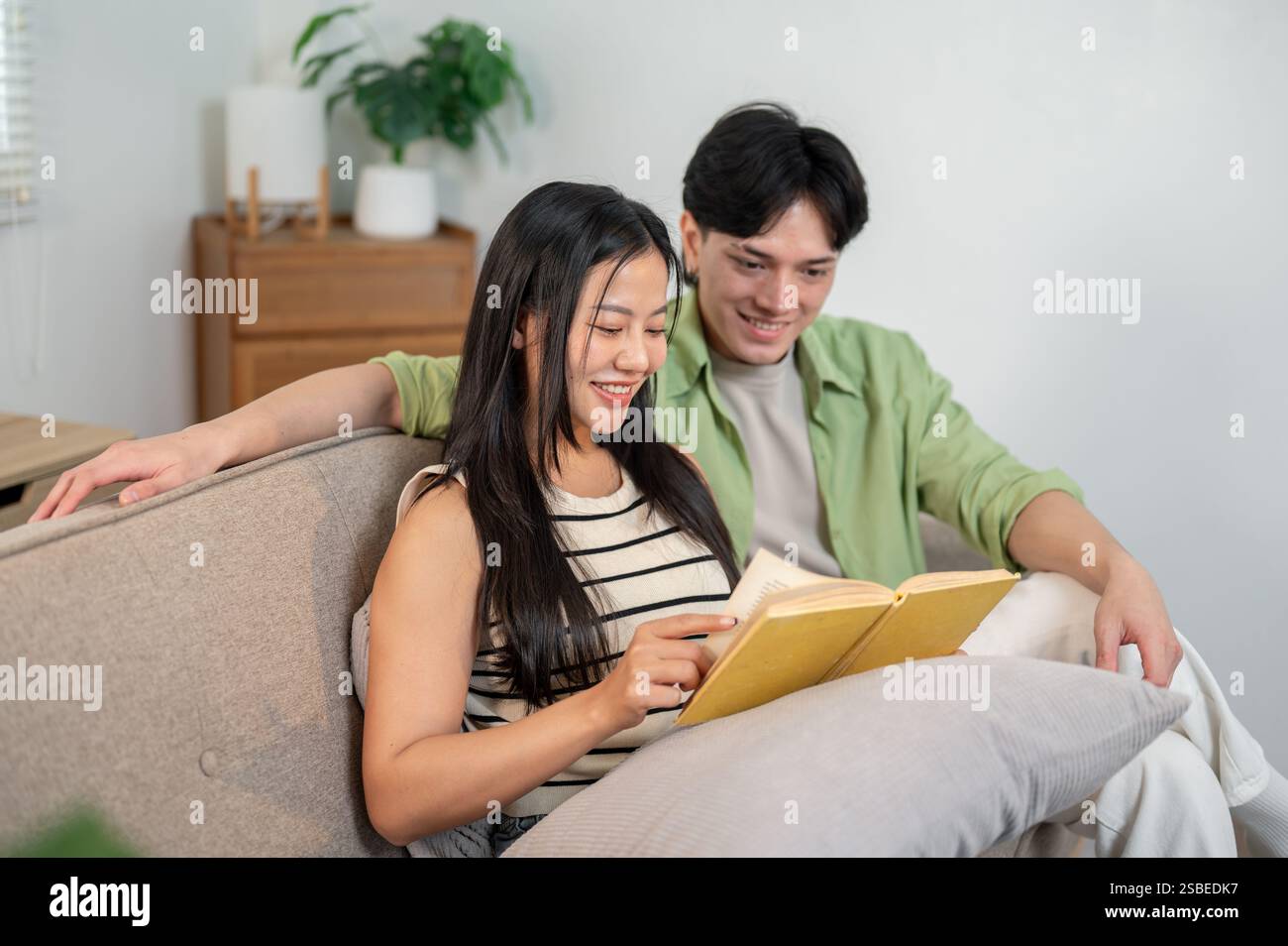A lovely, happy young Asian couple, a boyfriend and girlfriend, enjoy ...