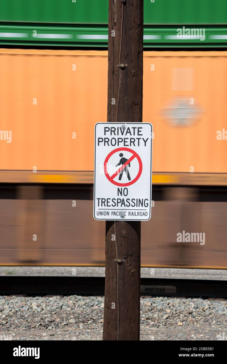 Train in motion behind a no trespassing sign in the rail yard in ...