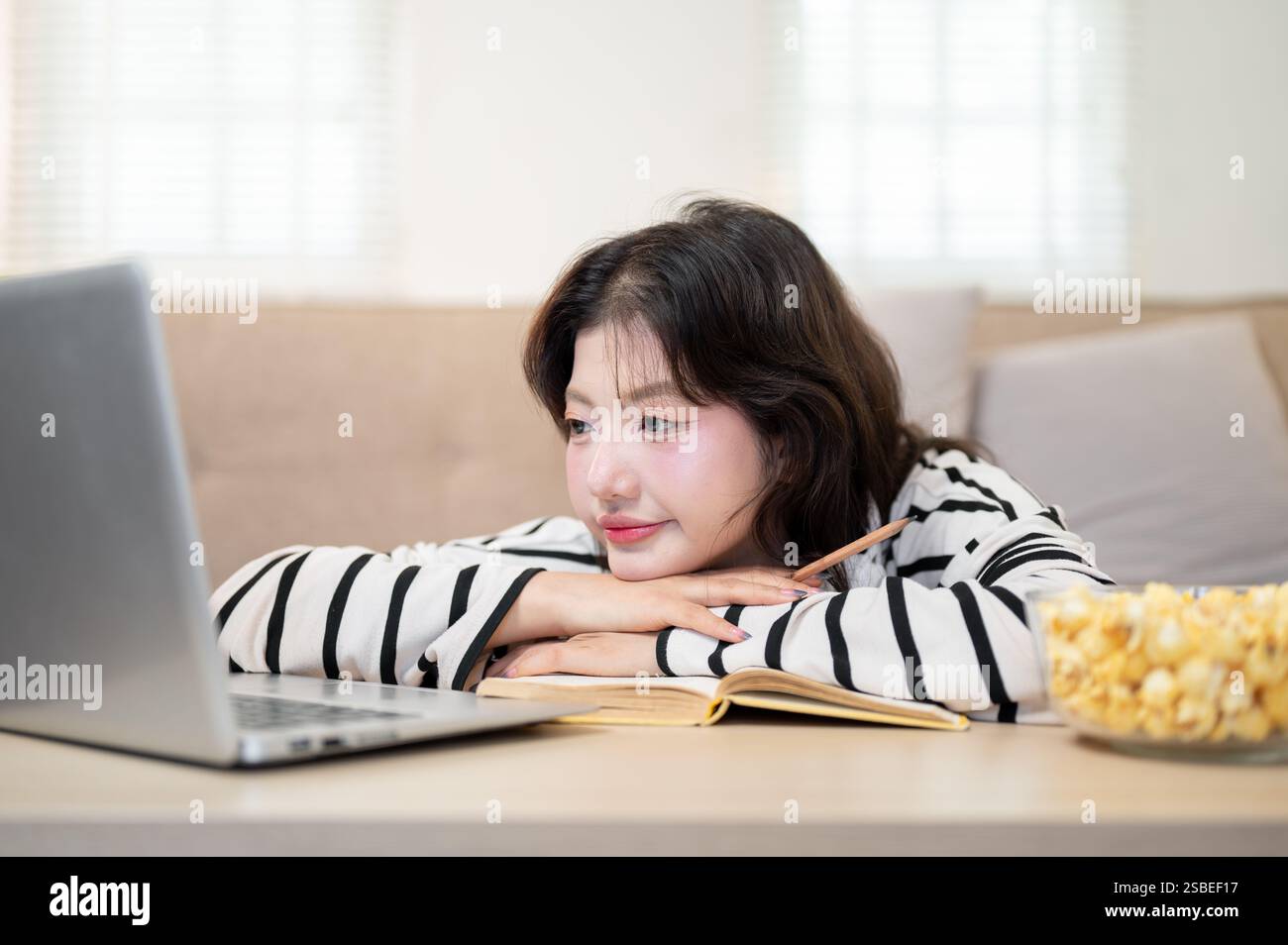 A tired young Asian female university student is feeling bored and ...