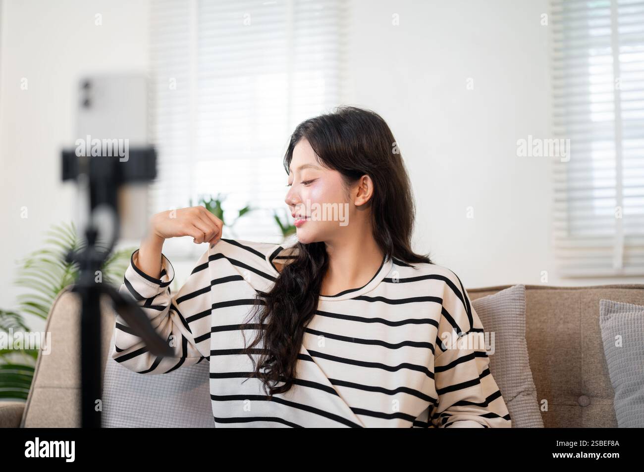 A beautiful, cheerful Asian female content creator or influencer is ...