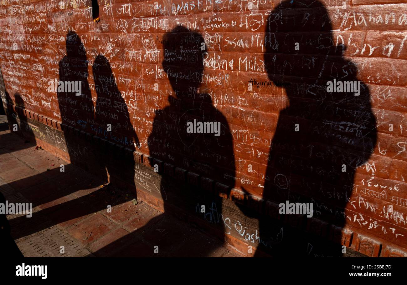 Shadows of devotees fall on the Saraswati temple wall, where they write ...