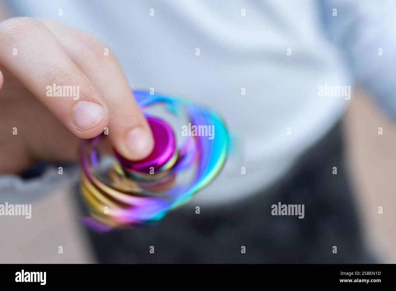 Child holding vibrant fidget spinner, twirling it with excitement ...