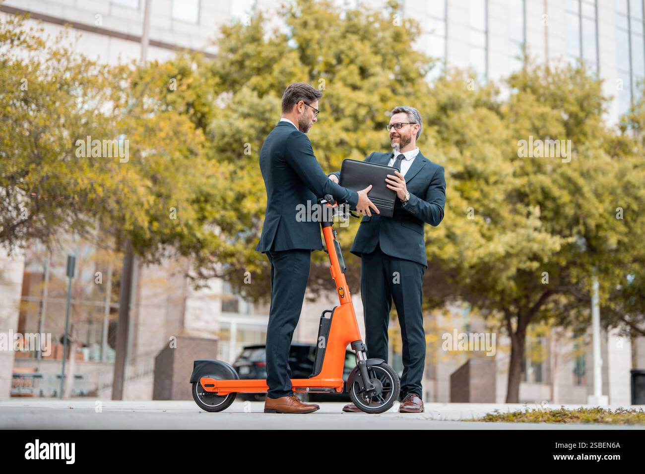 Two business men talking outdoors. Two diverse businessmen talking ...