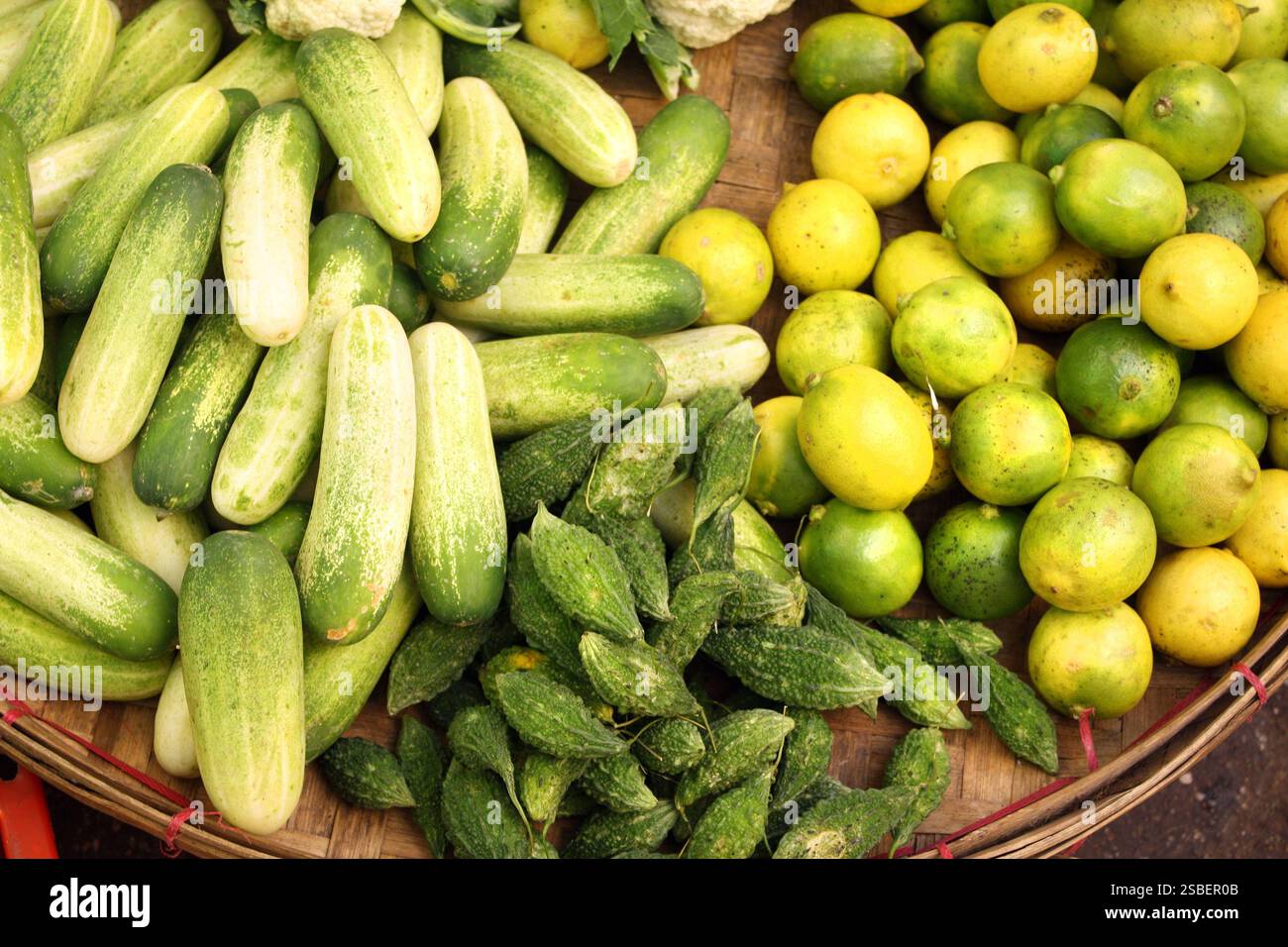 Different ripe vegetable in a wicker basket. Fresh cucumber, bitter ...