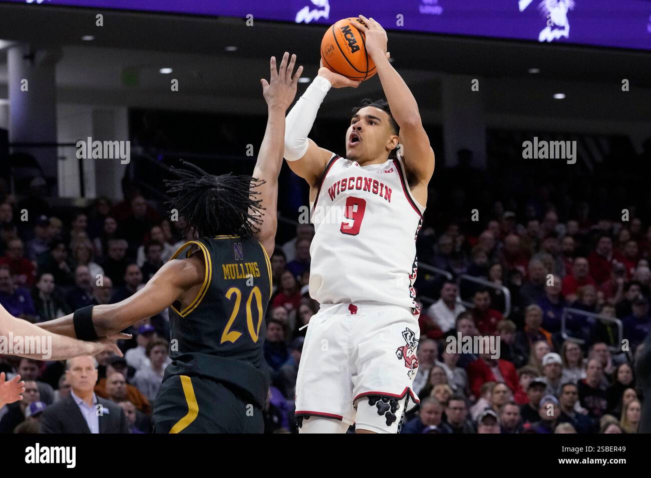 Wisconsin guard John Tonje (9) shoots over Northwestern guard Justin ...