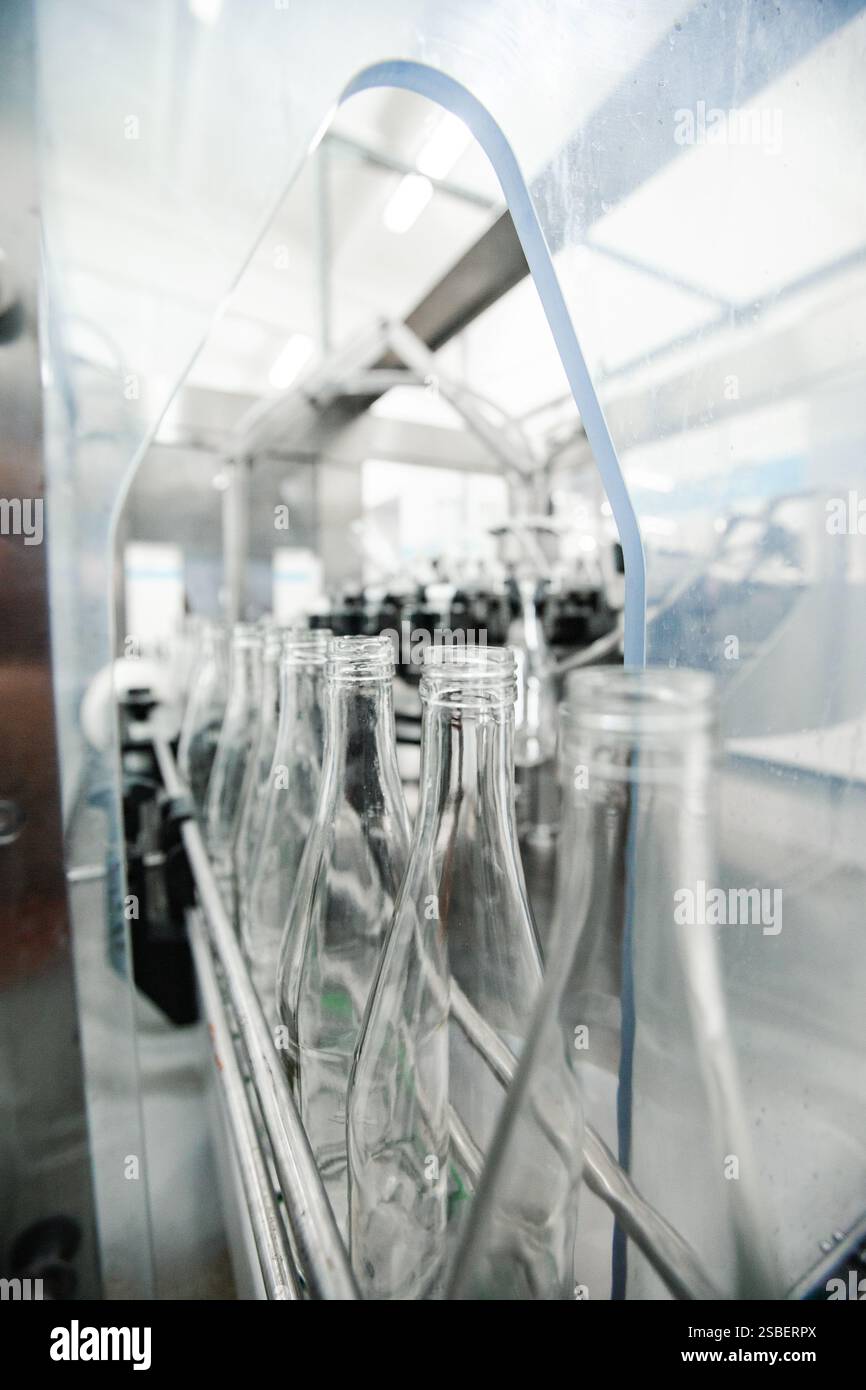 Bottling process in a modern factory during daytime with clear glass ...