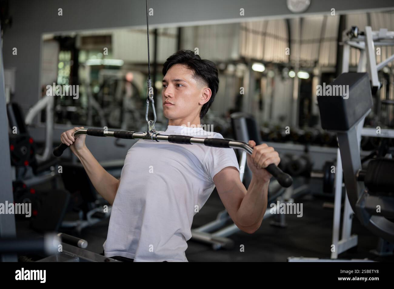 A strong and determined Asian man in sportswear is focused on working ...