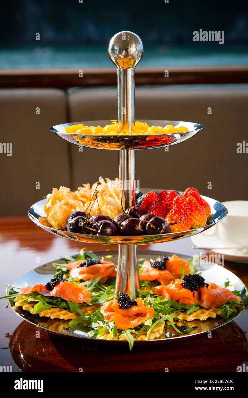 Afternoon tea with a three tiered snack server on a luxury motor yacht ...