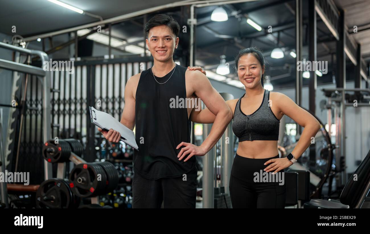 Two professional, confident Asian fitness instructors, male and females ...