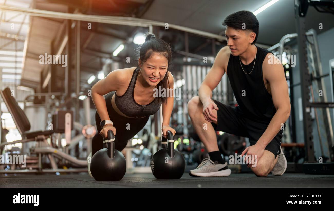 A determined Asian female client is being trained by a professional ...