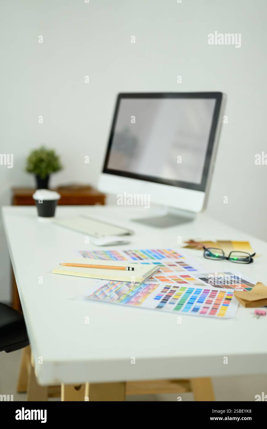 Creative designer workspace with computer monitor, color swatches and ...