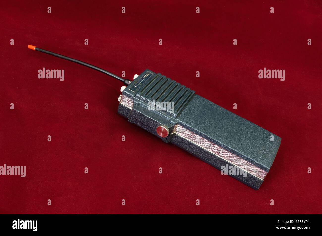 Vintage 1970's two-way radio handset with antenna. On red background ...